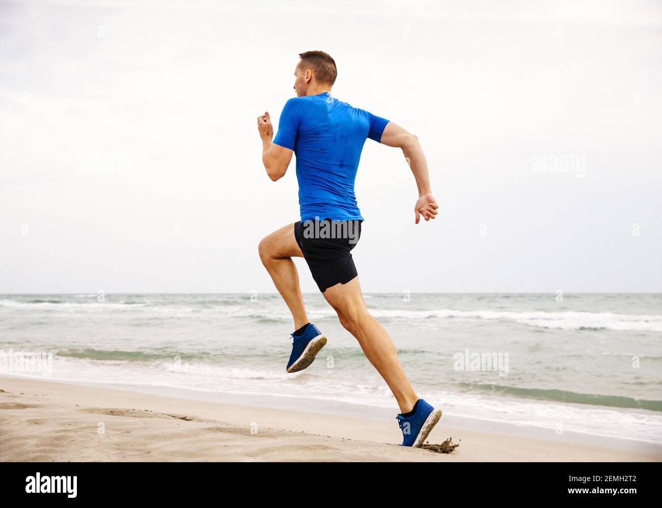 male runner running edge of sea sand beach Stock Photo - Alamy