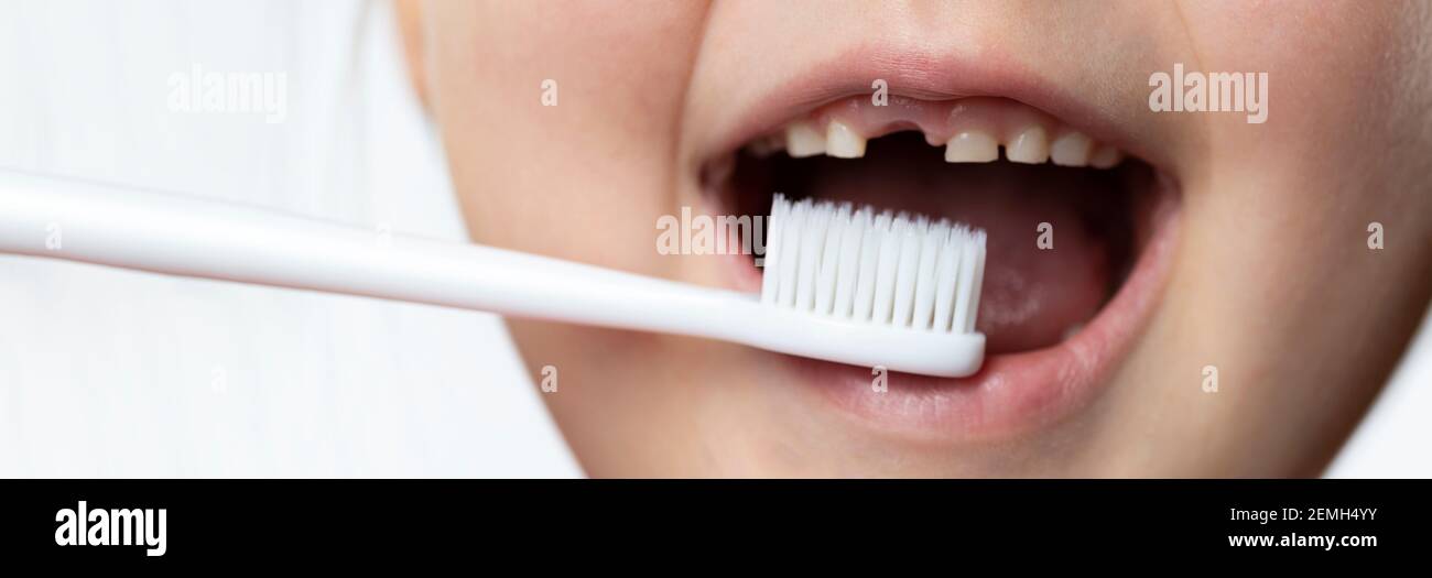 Baby's mouth with a milk tooth hole and a toothbrush. Teeth brushing ...