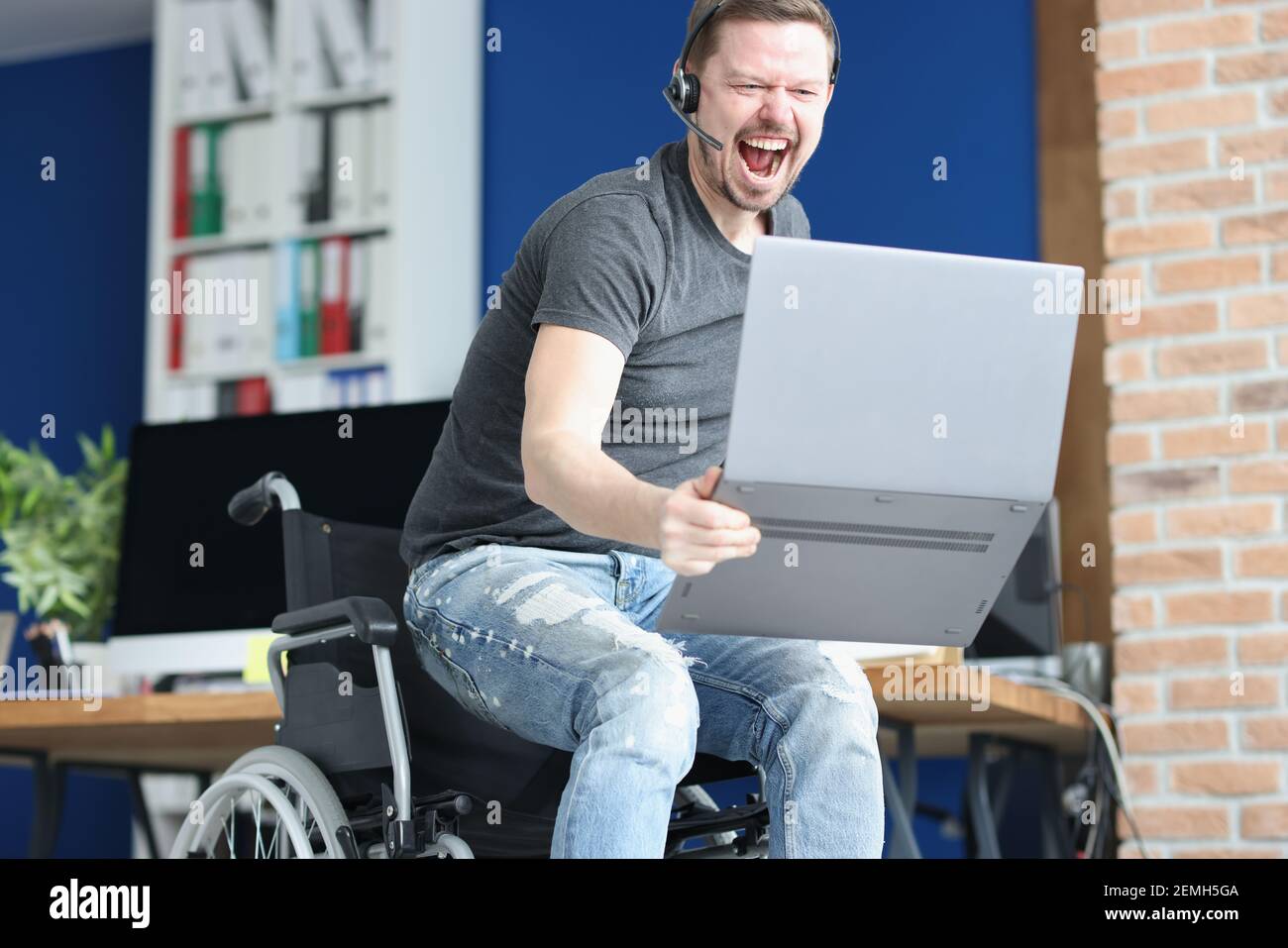 Happy man in laptop getting up from wheelchair Stock Photo - Alamy