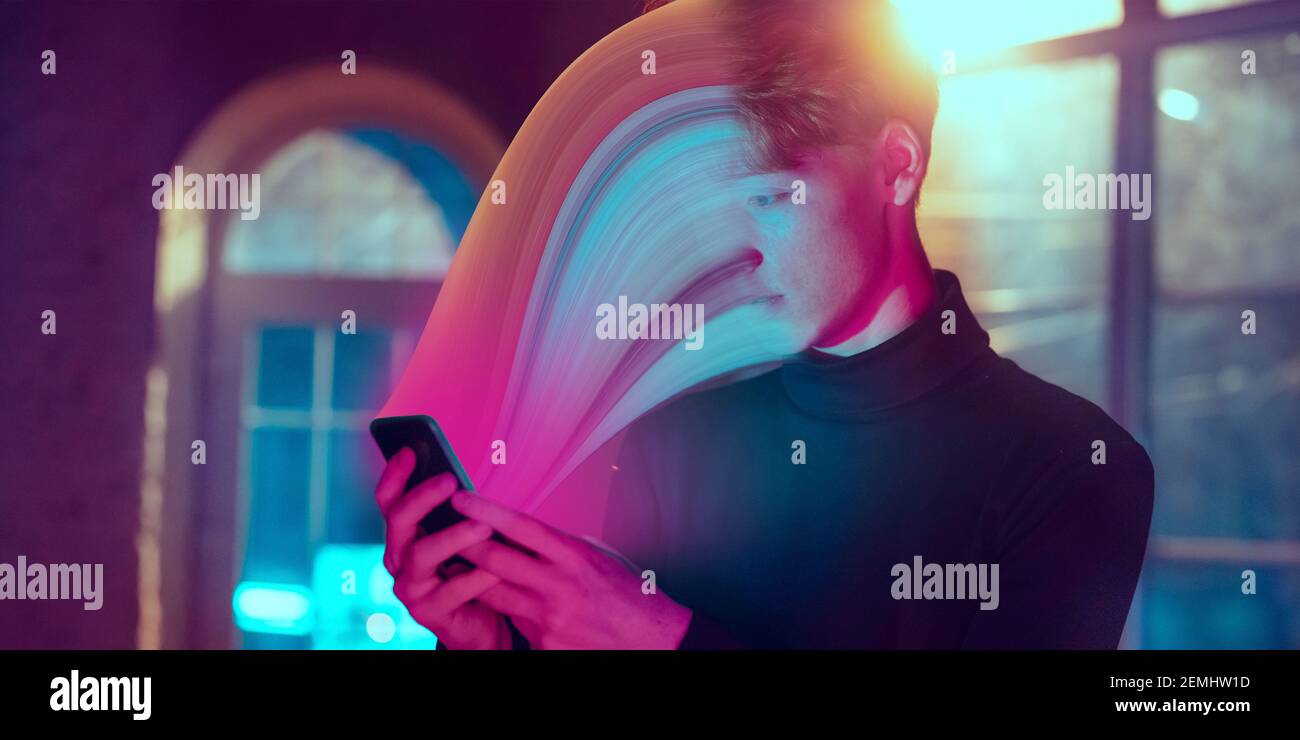 Cinematic portrait of stylish man in neon lighted interior using a ...