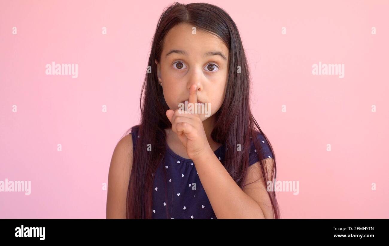 Girl show silent sign at pink background Stock Photo - Alamy