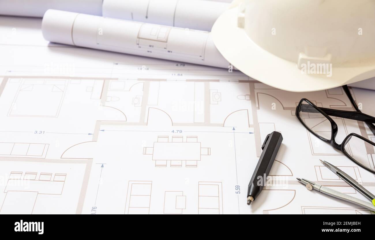 Project blueprints and engineer hardhat white color on drawings ...