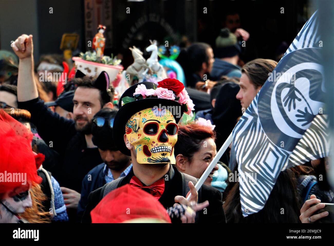 A man seen wearing a day of the dead skeletal mask and holding a flag ...