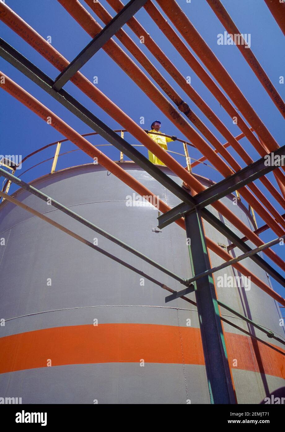 Worker standing on top of storage tank in chemical plant Stock Photo ...