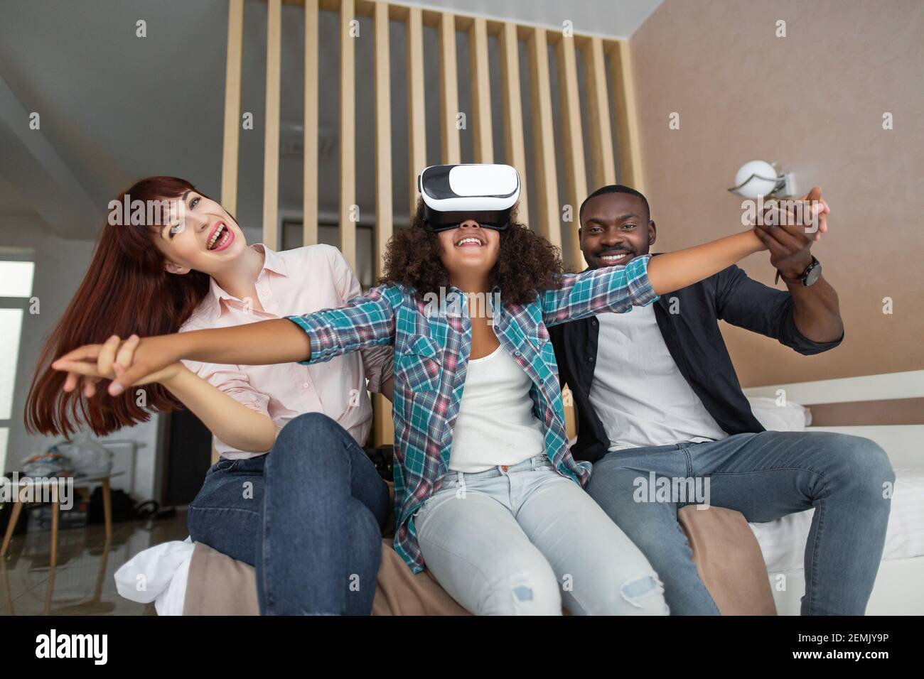 Virtual world. Happy young family of three having fun using VR glasses ...