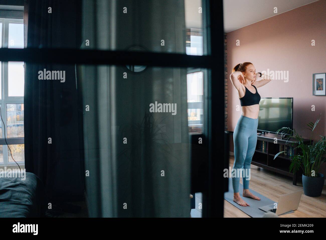 Remote side view of fit woman doing stretching exercise for arms and ...