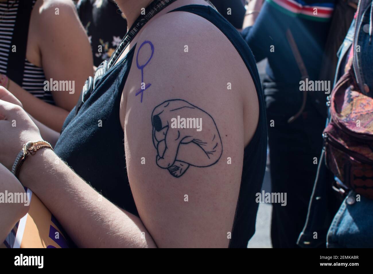 A woman seen with a gender symbol on her arm during the protest ...