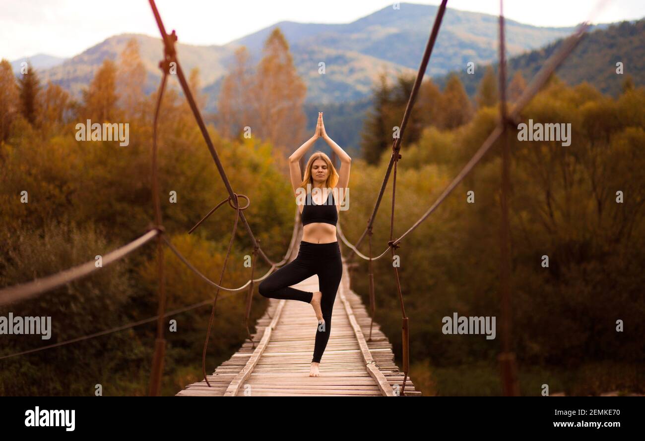 Yoga outdoor. Young woman do yoga balance exercises. Yoga meditation on ...