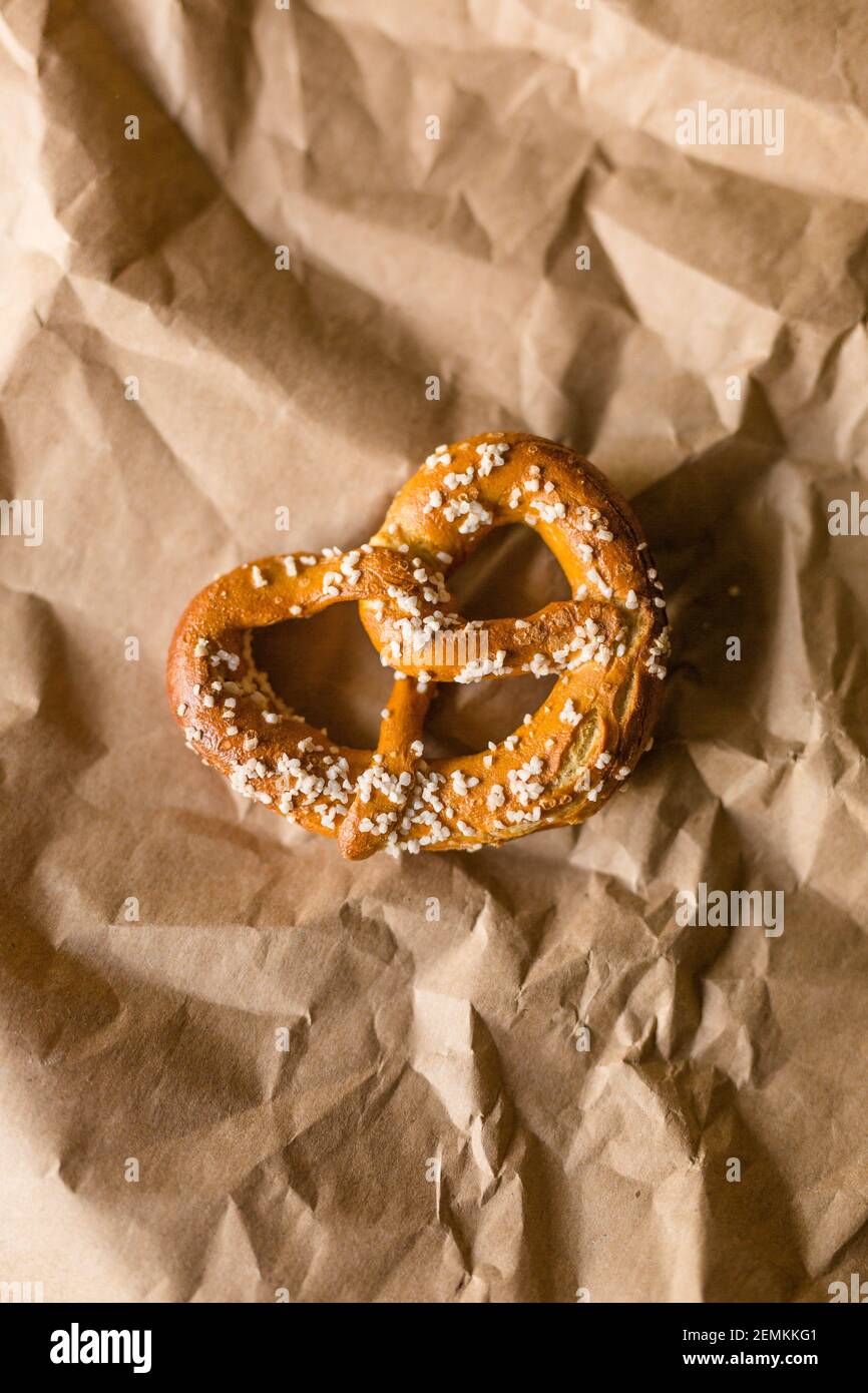 Hard Twisted Pretzel with Salt Against Brown Paper Background Stock ...
