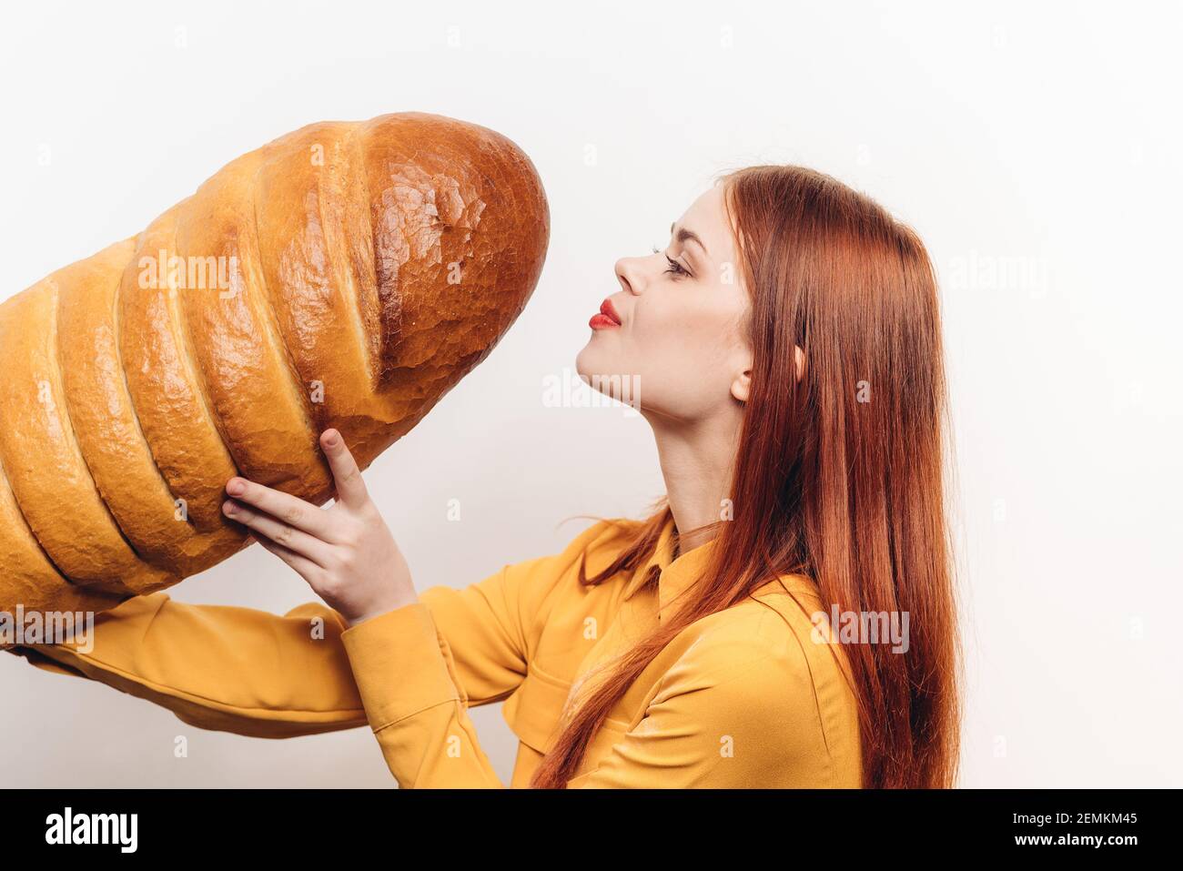 beautiful woman with a loaf of bread on a colored background fun ...