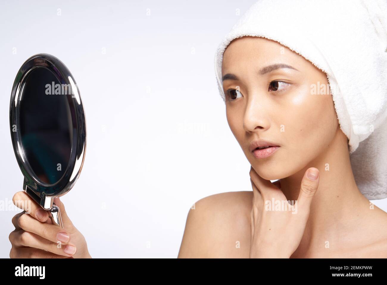 woman of asian appearance looking in the mirror skin care health spa ...