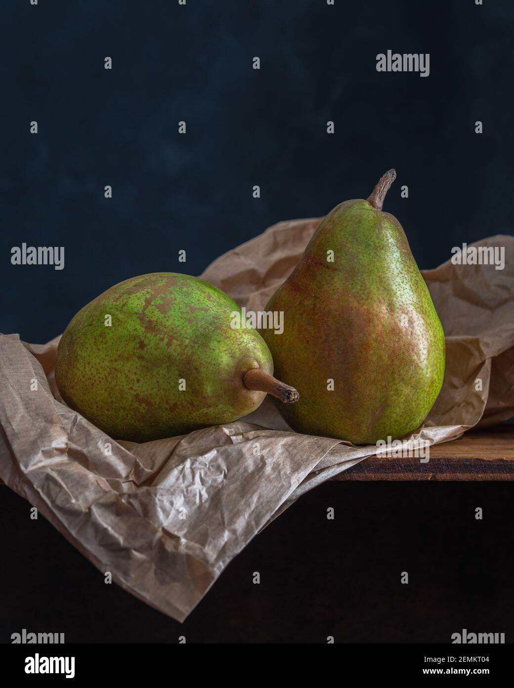 Two beautiful conference pears on a paper bag on black background, copy ...