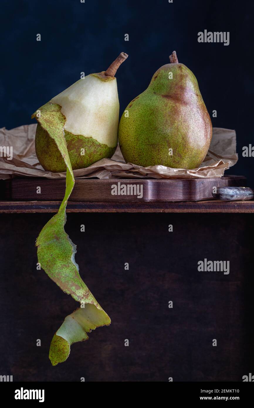 Two beautiful conference pears on a paper bag, one pear cut open with ...