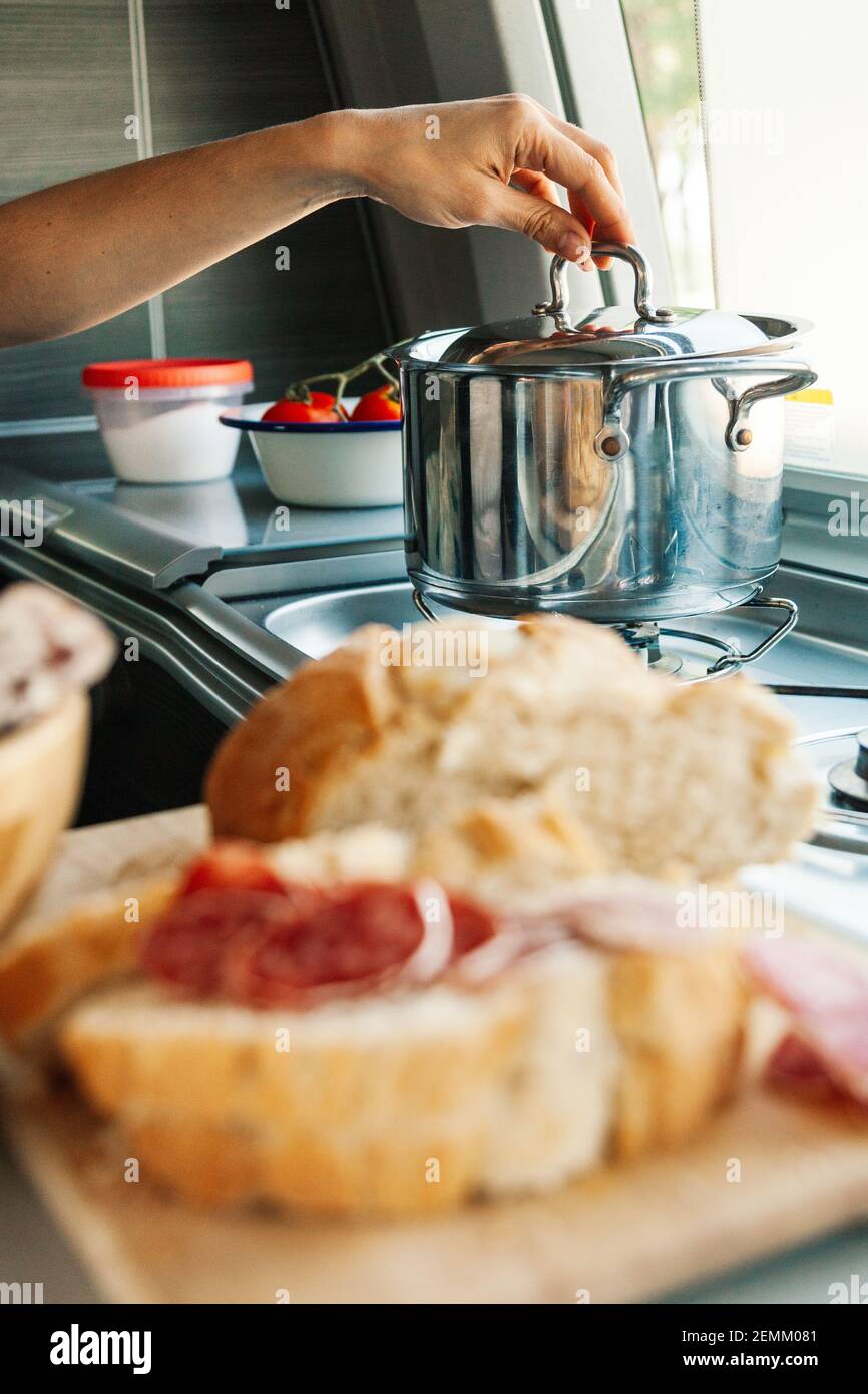 A young woman having breakfast in her caravan observing a good view of ...