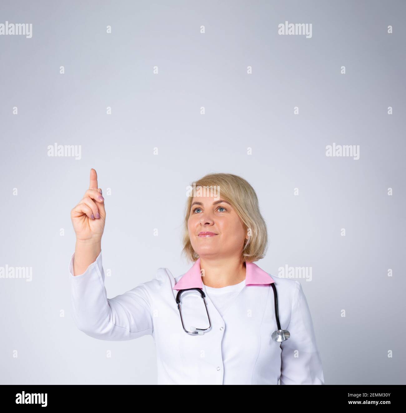 Excited doctor, blonde woman isolated on gray background. Female doctor ...