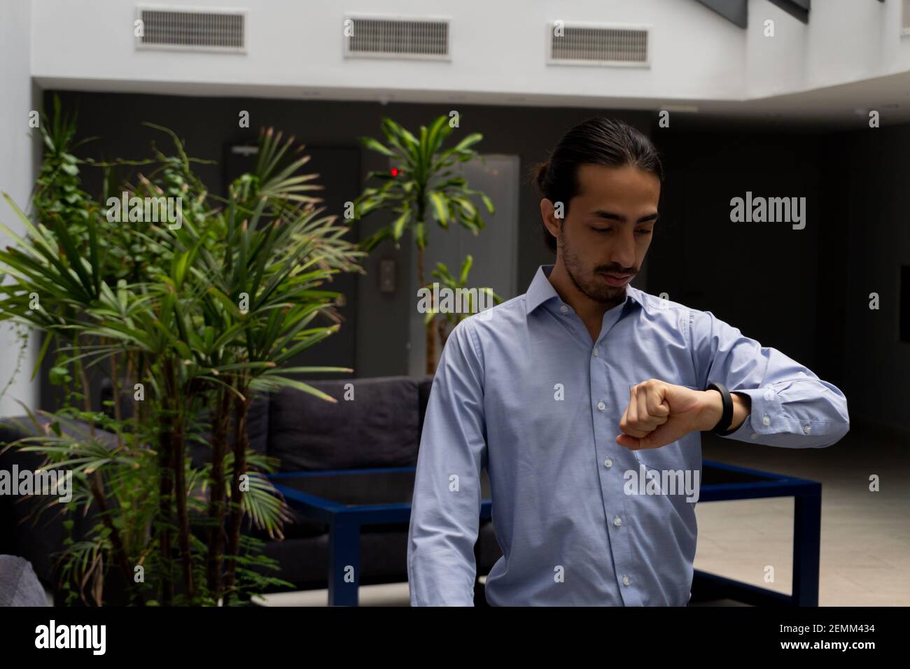 Businessman checking watch in office hi-res stock photography and ...