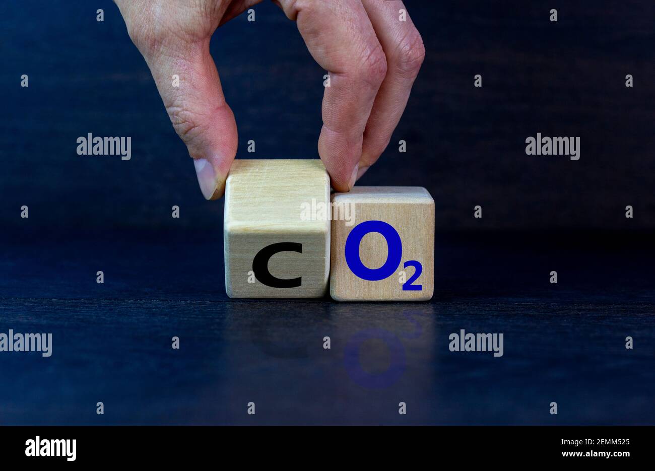 CO2 or O2 symbol. Businessman turns the wooden cube and changes words ...