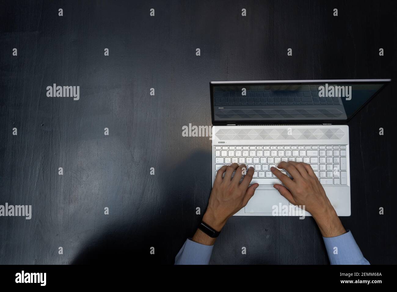 over head view of a modern computer all gray on top of a black textured ...
