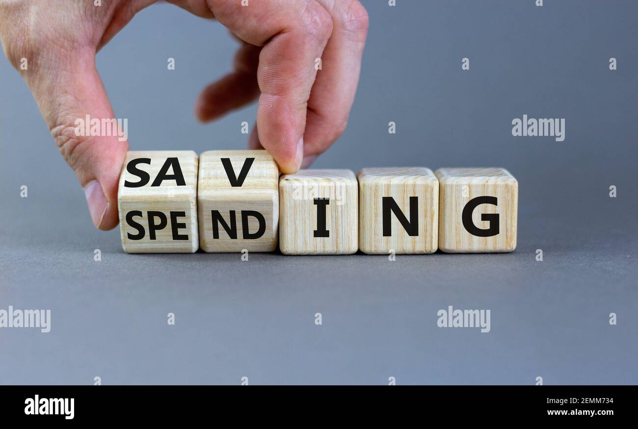 Saving or spending symbol. Businessman turns cubes and changes the word ...