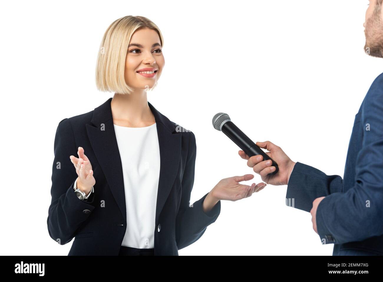 smiling blonde businesswoman talking near interviewer with microphone ...