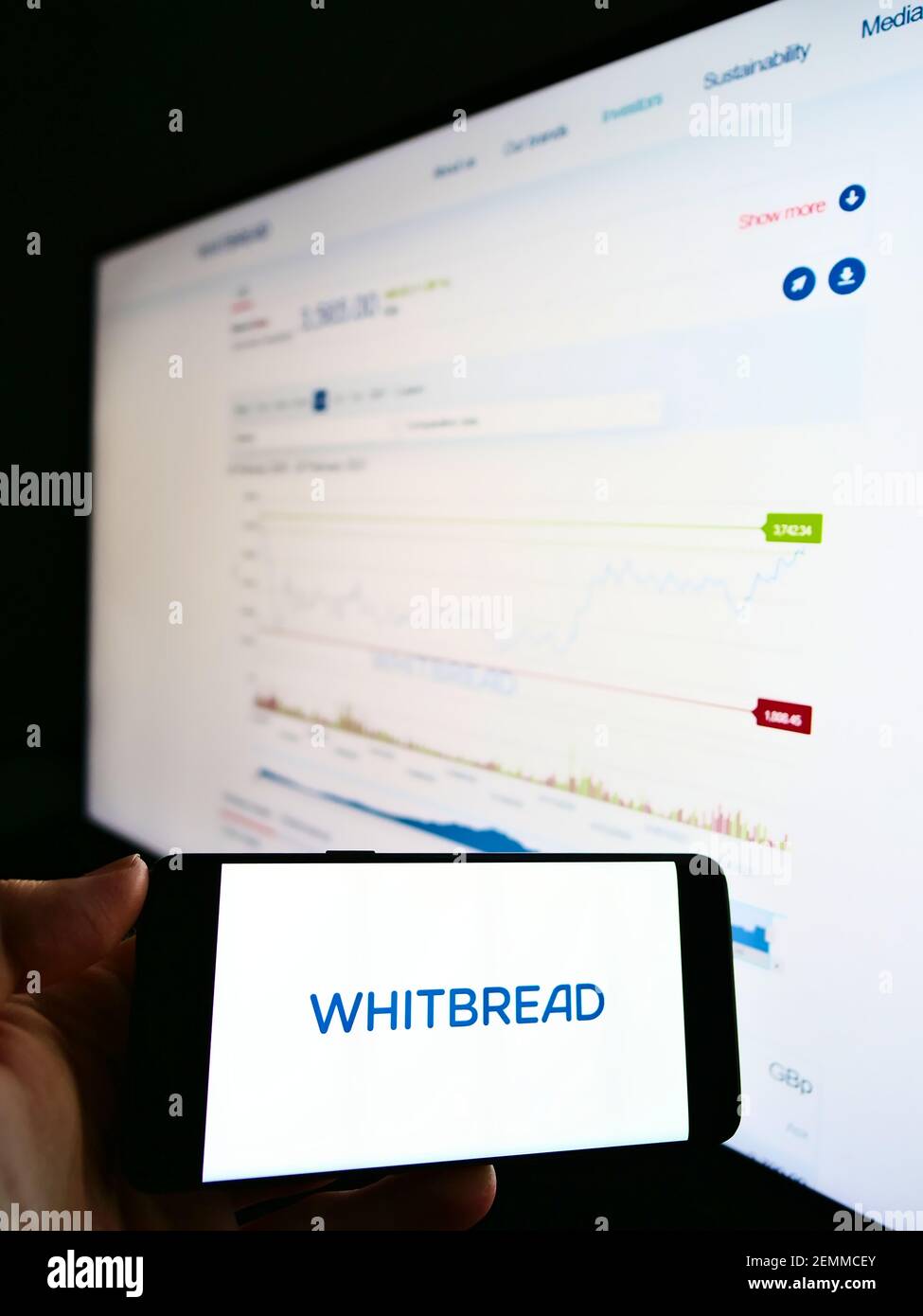 Person holding cellphone with logo of British hotel company Whitbread ...