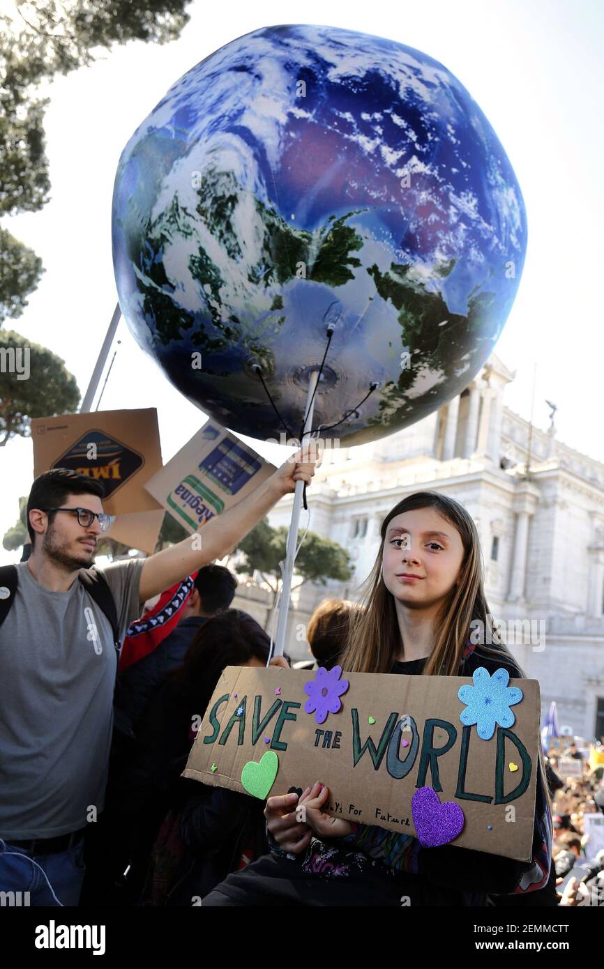 A child carrying a banner with save the world and a huge globe Stock ...