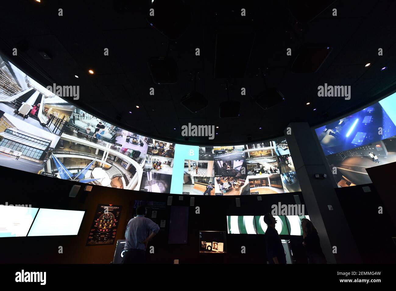 Visitor look up at surveillance monitors inside the Spy Museum in New ...