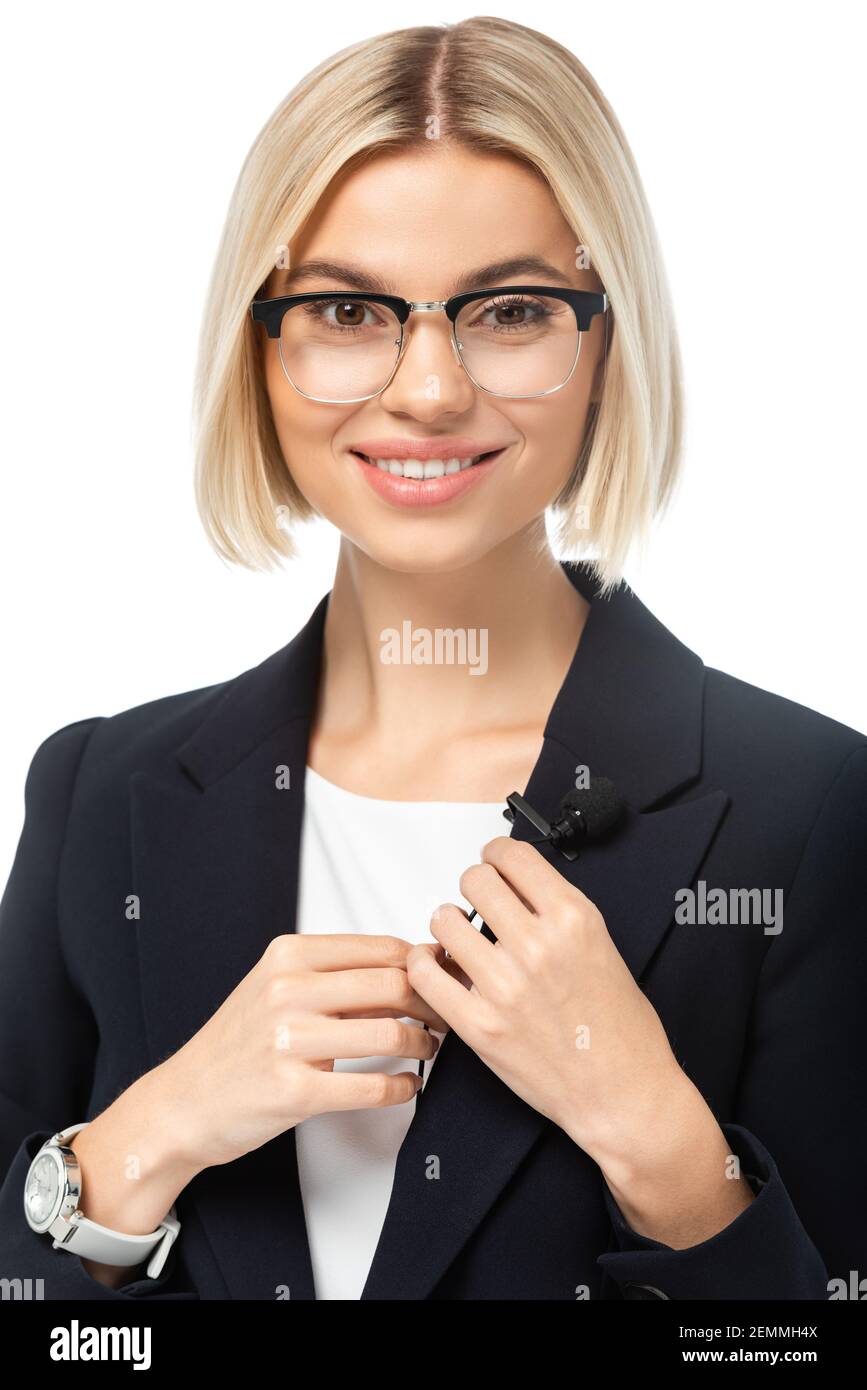 cheerful news presenter looking at camera while fixing microphone on ...