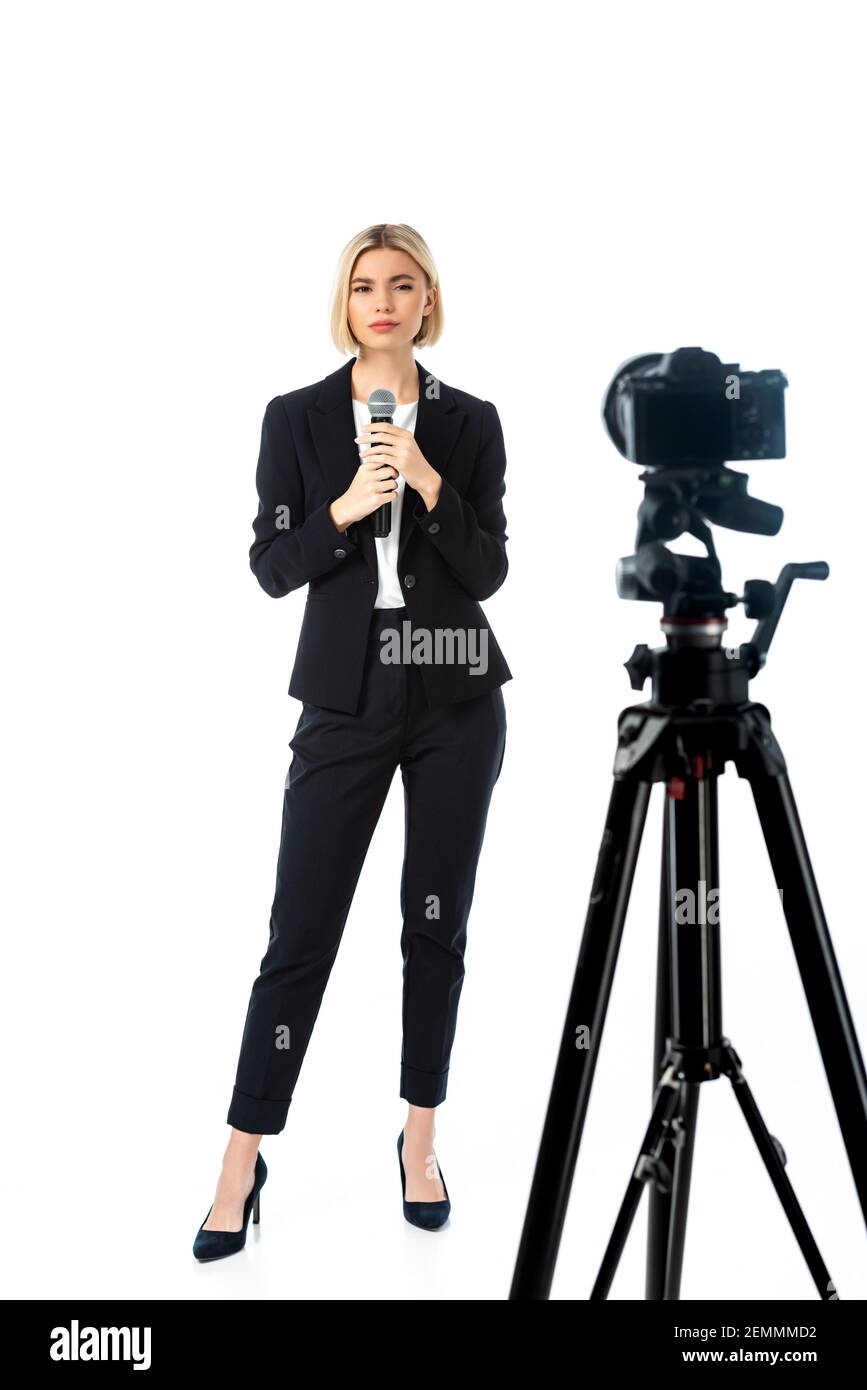 full length view of blonde news anchor with microphone near digital ...