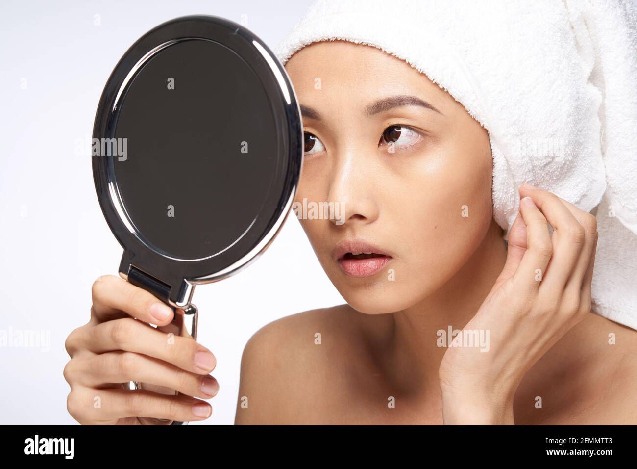 woman of asian appearance looking in the mirror skin care health spa ...