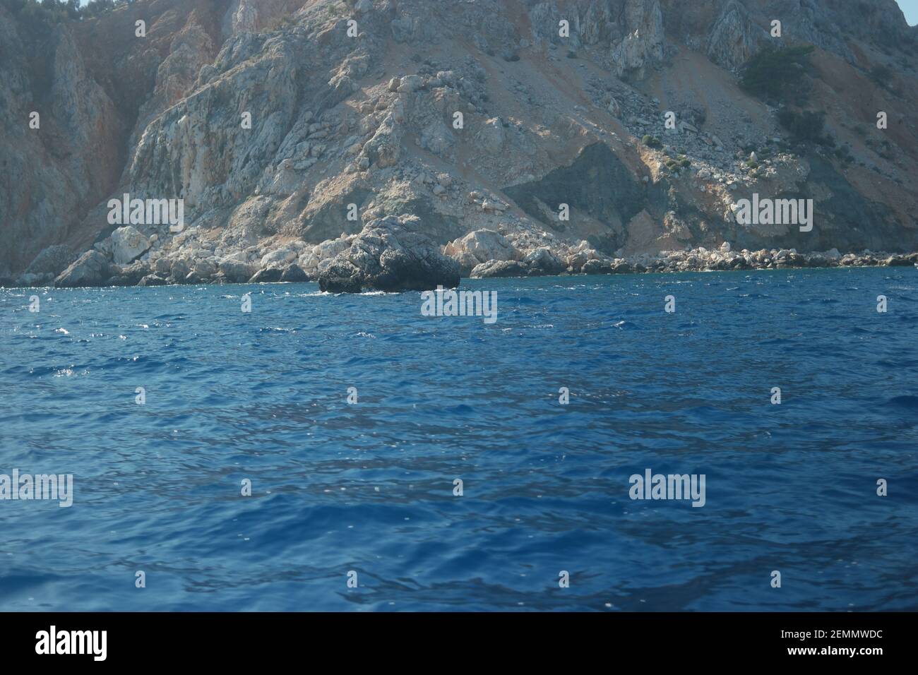 Rock formation in blue ocean water Stock Photo - Alamy