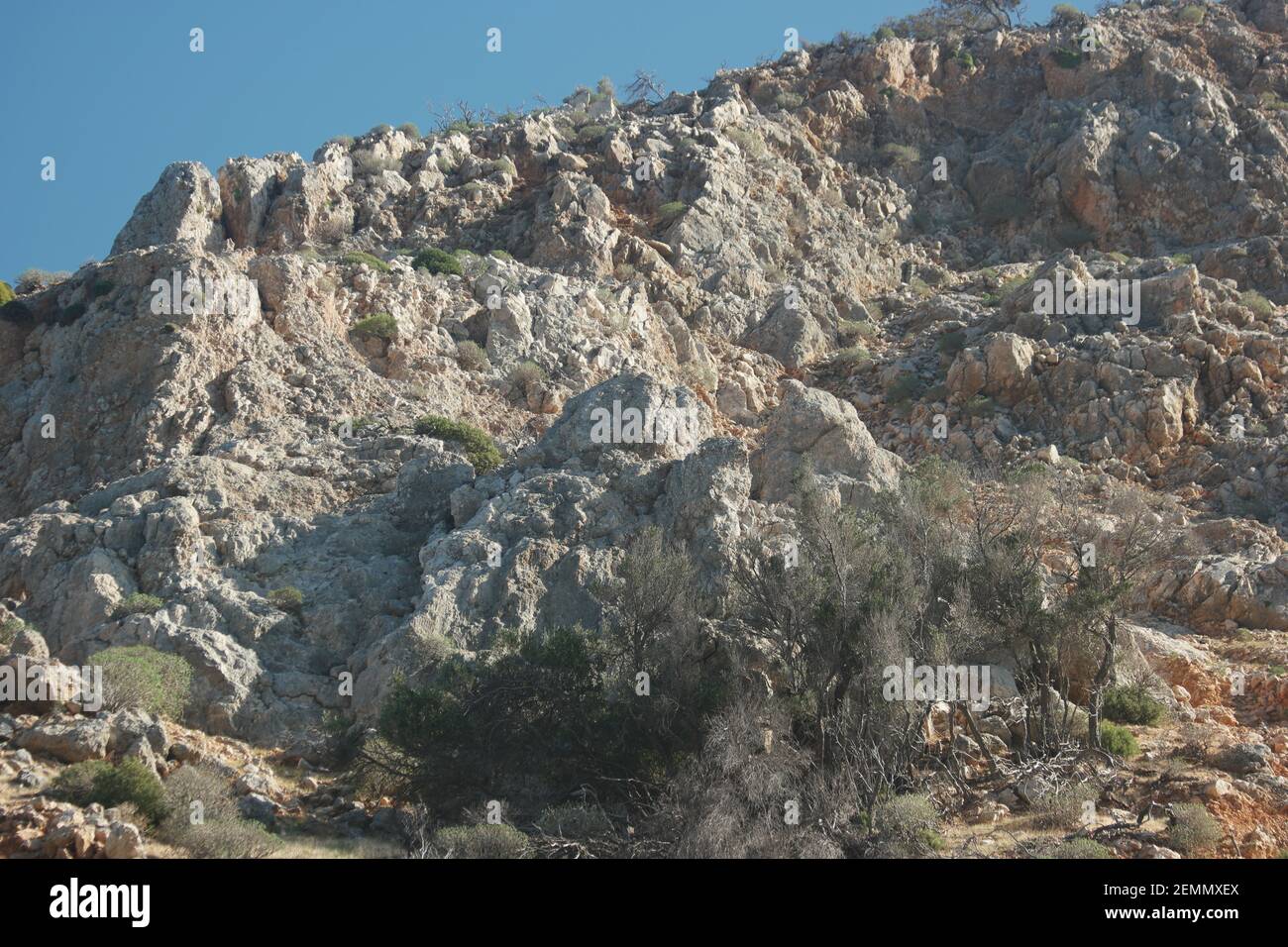 Rocky cliff on blue sky background Stock Photo - Alamy