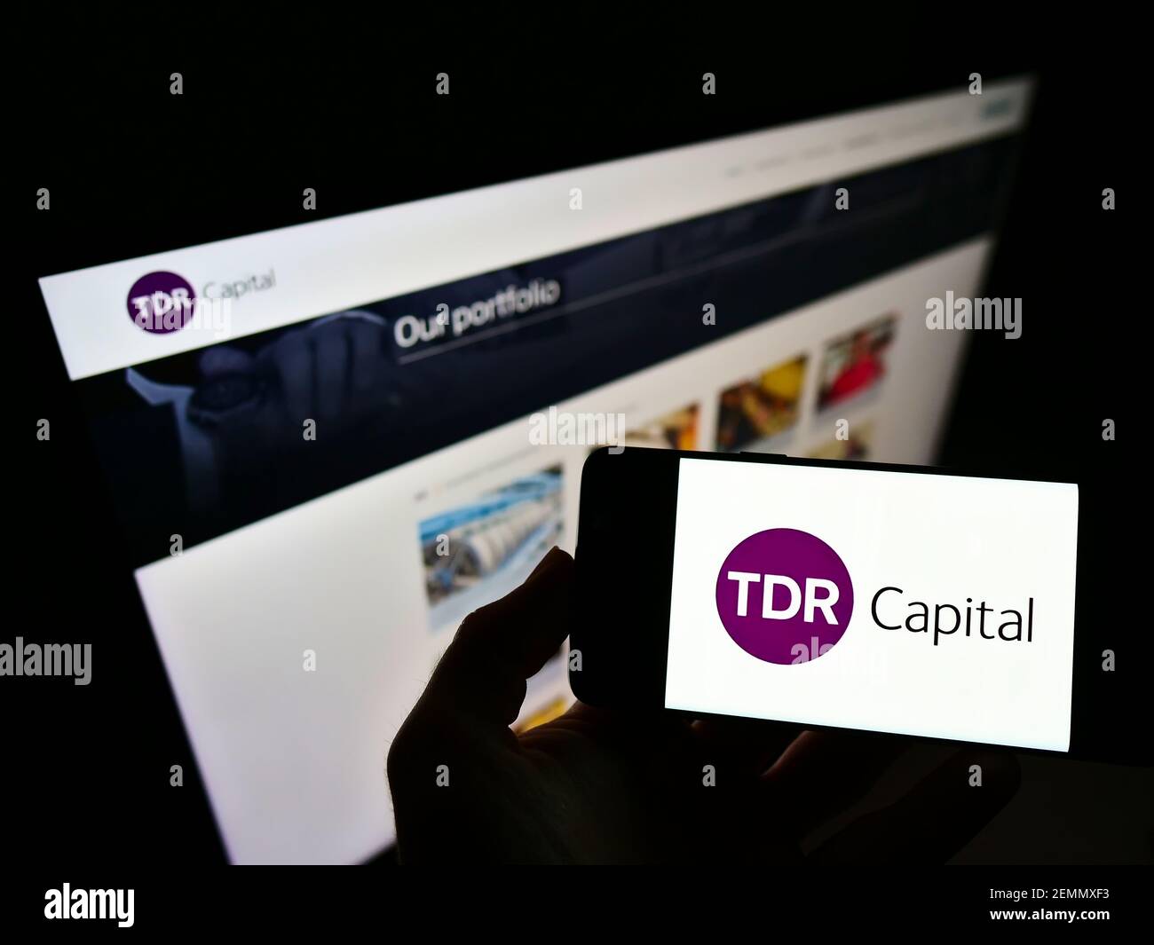 Person holding mobile phone with business logo of British investment firm TDR Capital LLP on ...