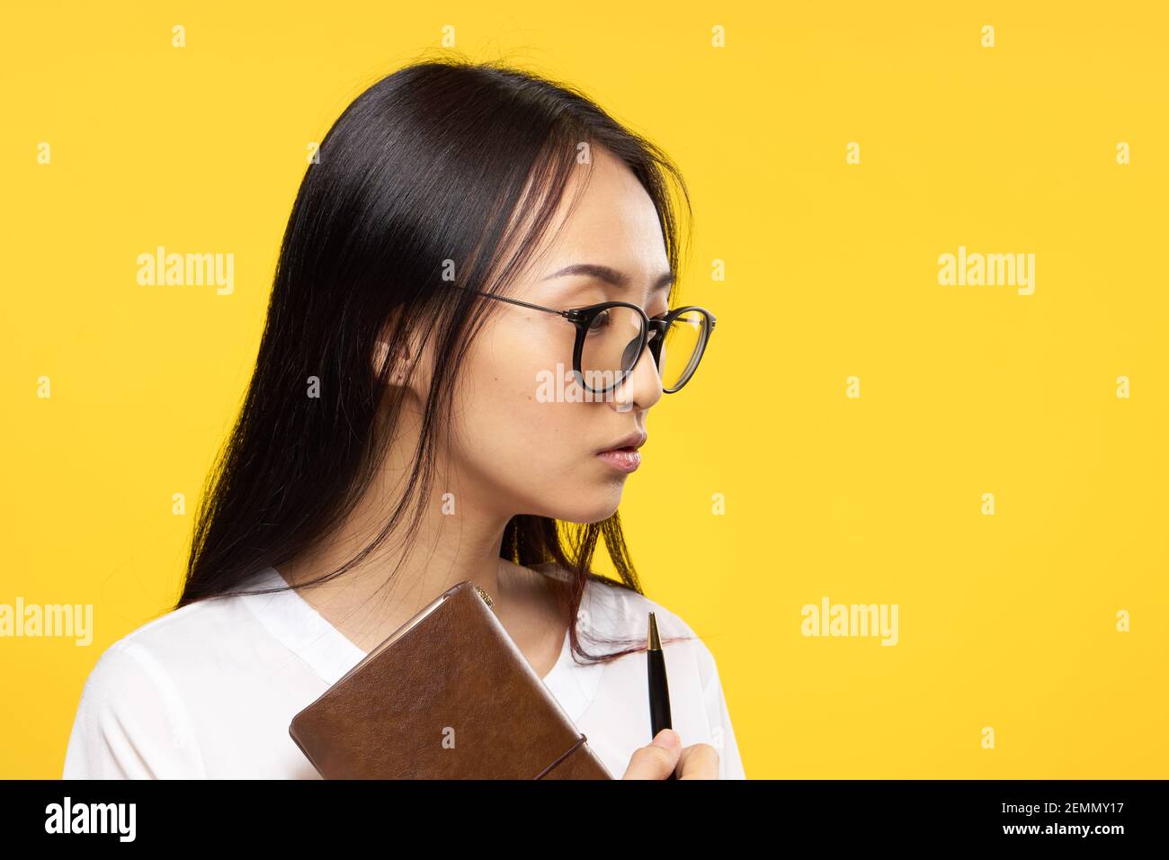 pretty brunette in white shirt holding notepad with pen office yellow ...