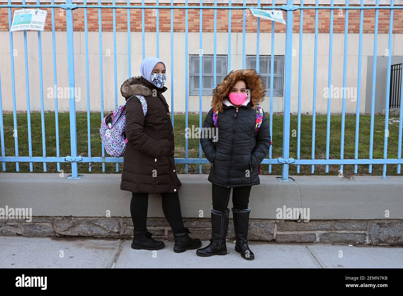 Students wear masks as they wait in line to resume in-person learning ...