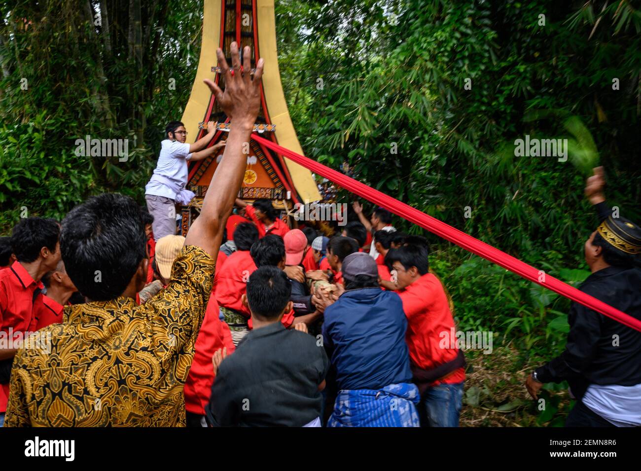 Residents are seen pulling red cloth and their relatives' coffins ...