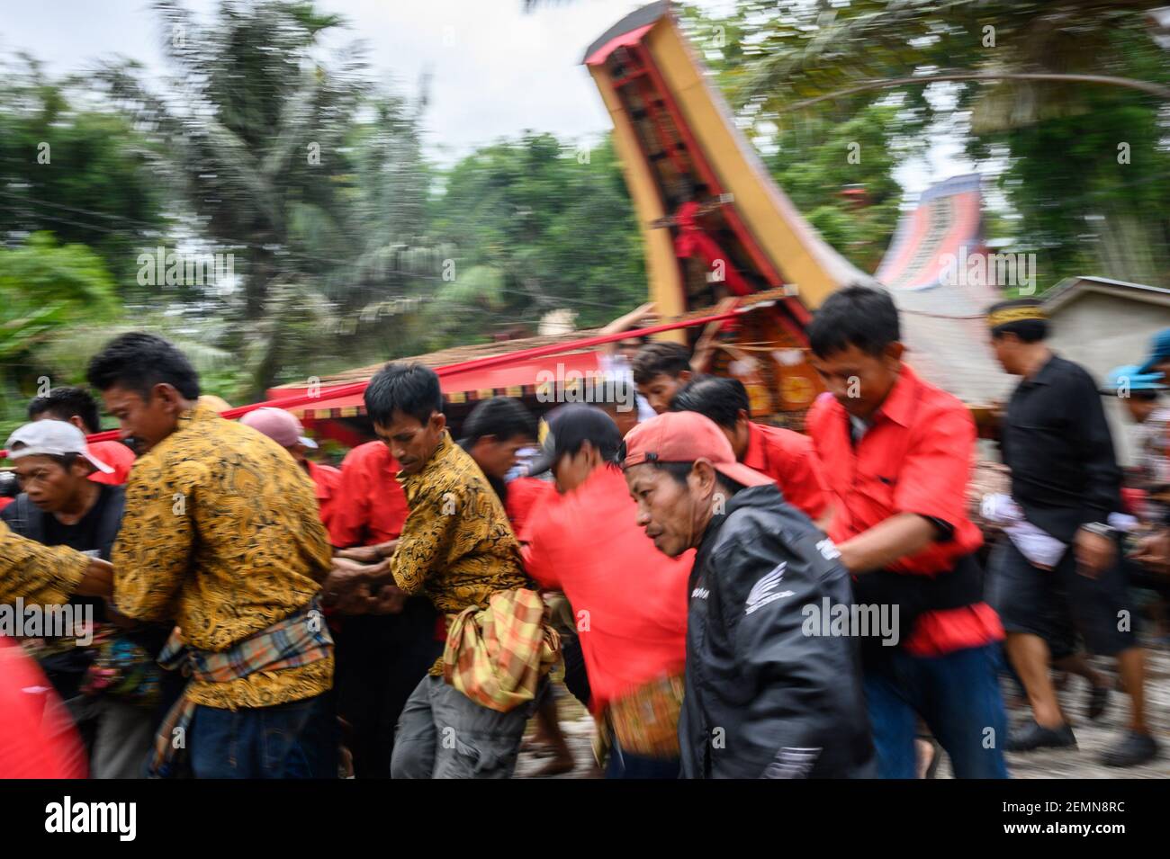 Residents are seen pulling red cloth and their relatives' coffins ...