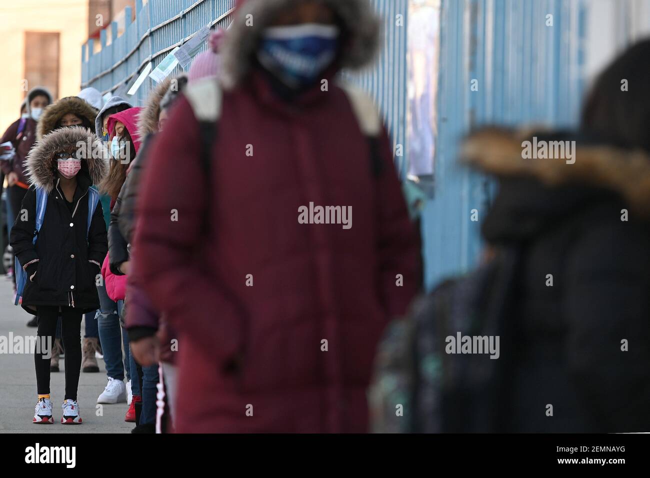 Returning students wear masks as they wait in line to resume in-person ...