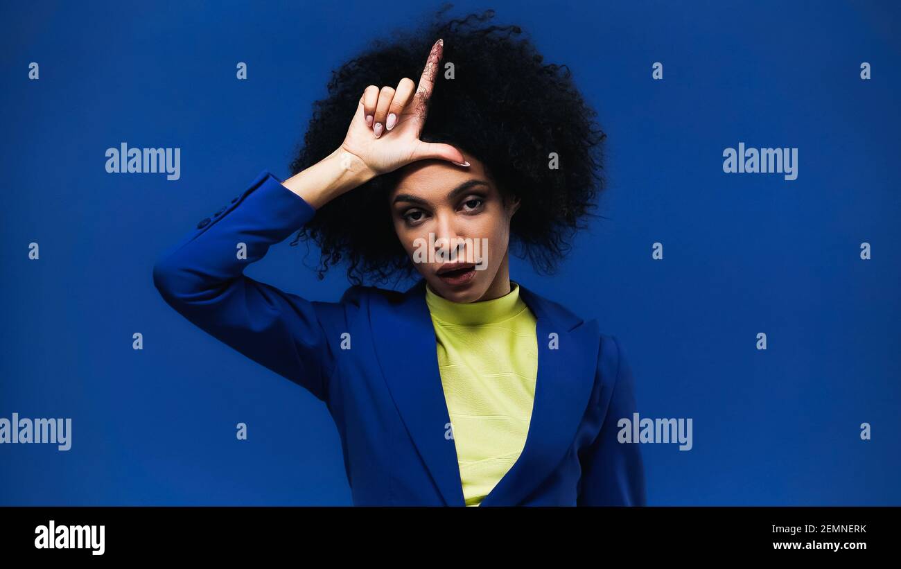 African american woman showing loser sign isolated on blue Stock Photo ...
