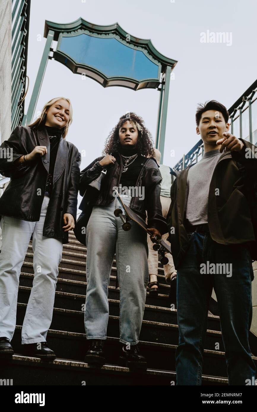 Portrait of friends standing on staircase at subway Stock Photo - Alamy