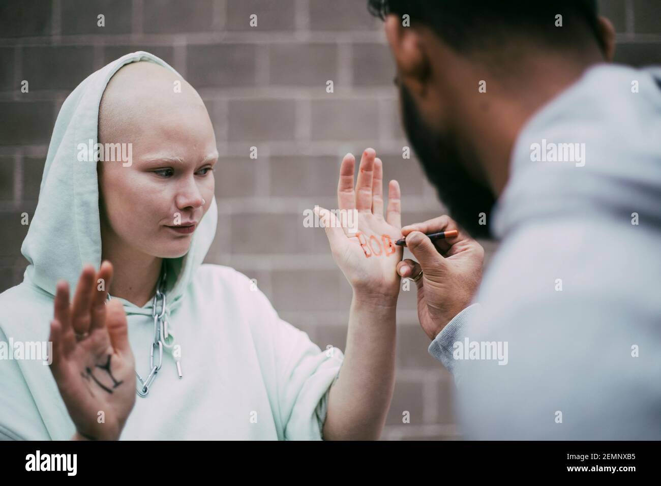 Male activist writing on female protestor's hand Stock Photo - Alamy