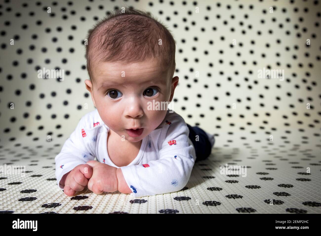 Curious little baby lying on bed Stock Photo - Alamy