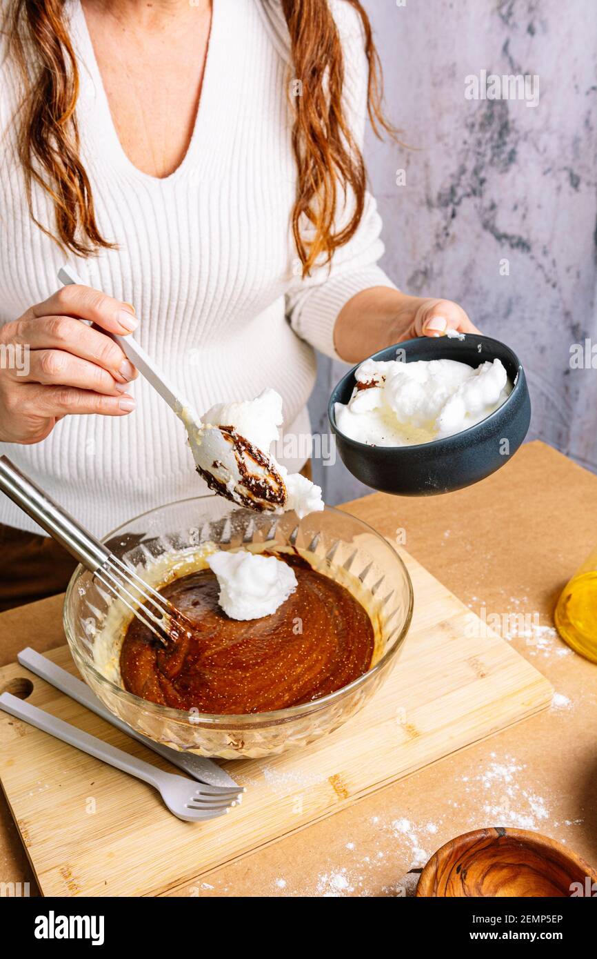 Woman preparing and cooking a chocolate sponge cake. Concept of ...