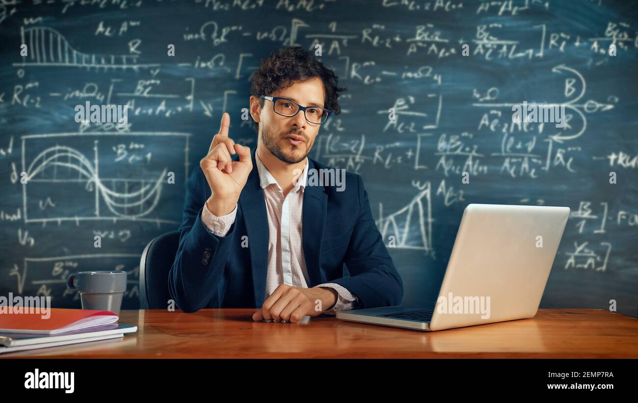 E-Education Concept: Teacher Sitting at Desk, Explains Lesson to a ...