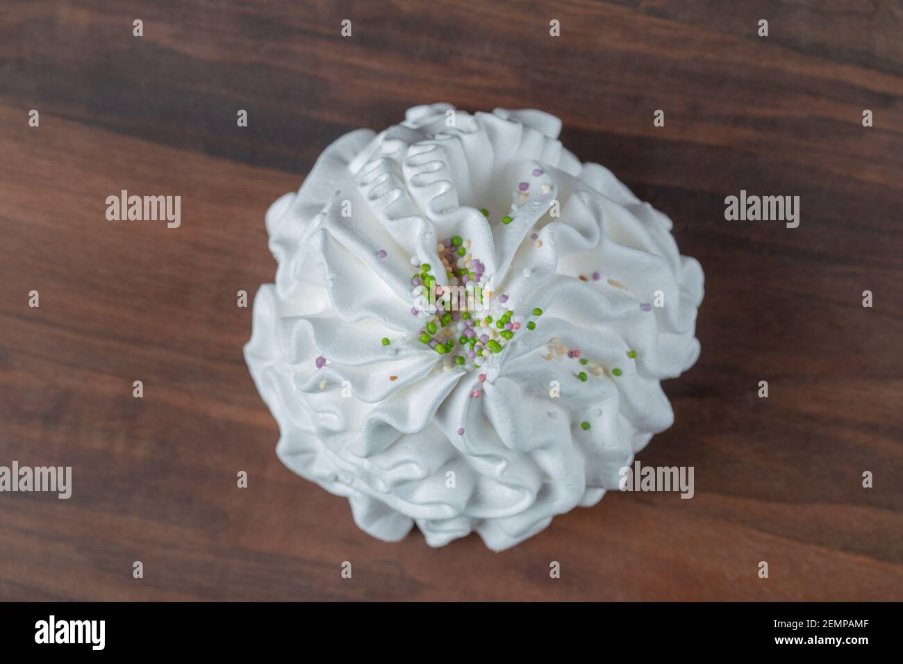 A single white isolated meringue cookie on the ground Stock Photo - Alamy