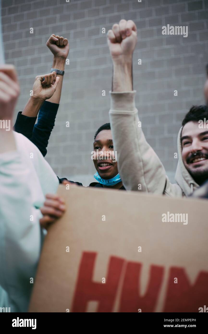 Smiling male activists with raised fit in movement Stock Photo - Alamy
