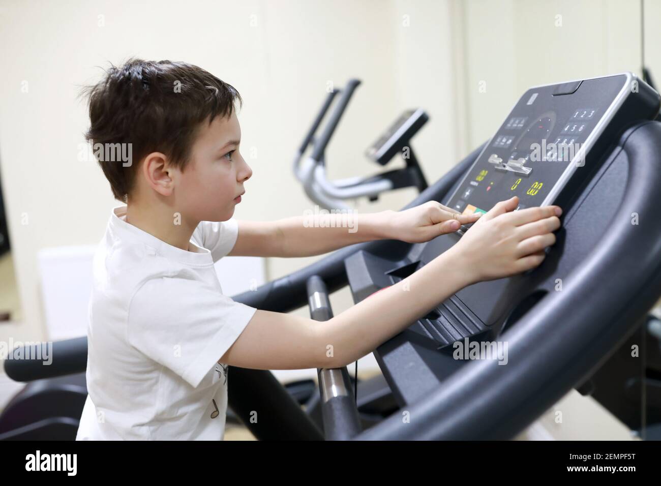Boy exercising at stride treadmill in gym Stock Photo - Alamy