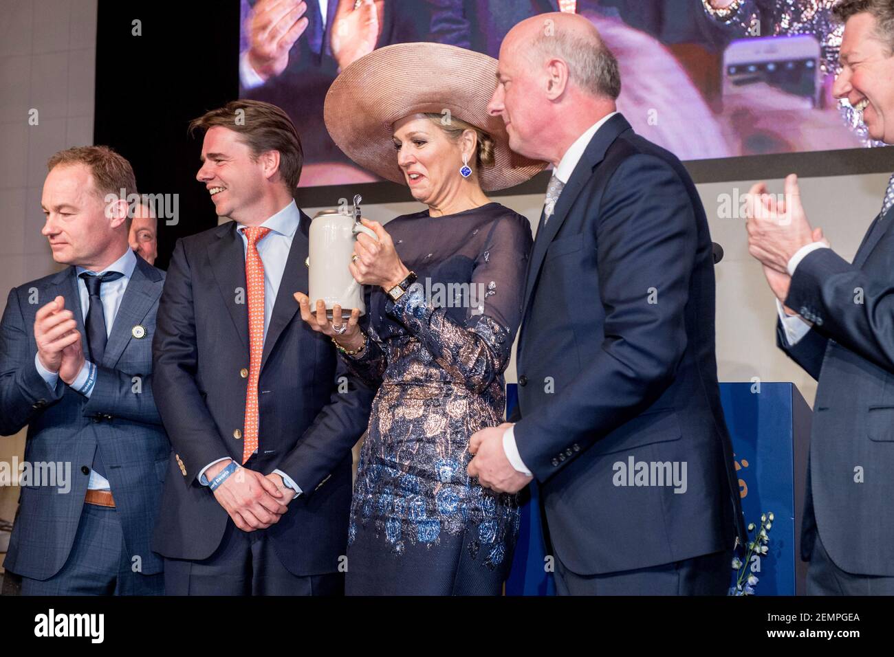 Queen Maxima drinks beer from a giant beer mug during the start of the ...