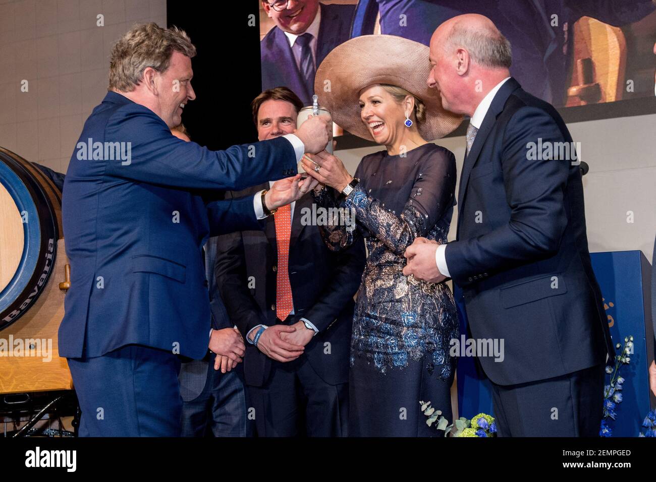 Queen Maxima drinks beer from a giant beer mug during the start of the ...