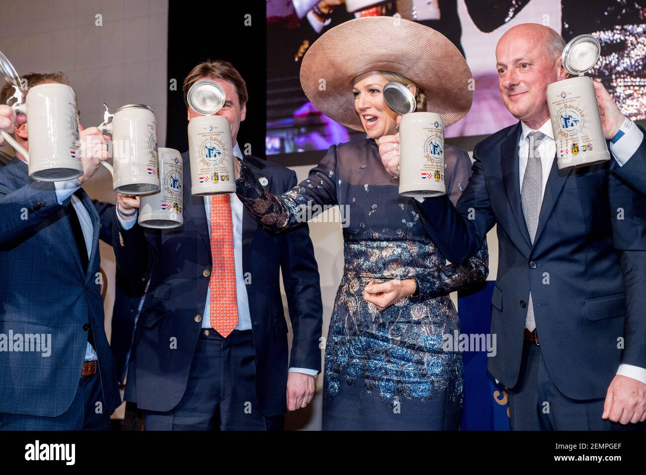 Queen Maxima drinks beer from a giant beer mug during the start of the ...